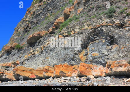 Steep slopes with sparse vegetation and visible layers of rock Stock ...