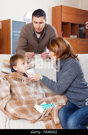 Adult couple giving tablets to son at home Stock Photo - Alamy