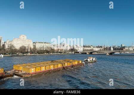 tug towing cory waste in sealed containers on barge in the river thames ...