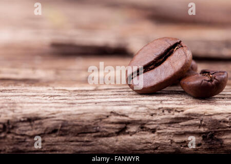 grains of coffee on rough wooden surface closeup Stock Photo - Alamy