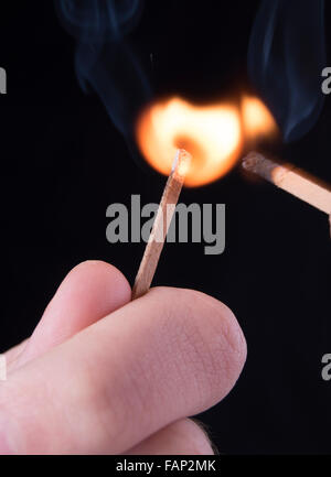 A closeup of the lit-up matches with orange-colored flame and a dark ...