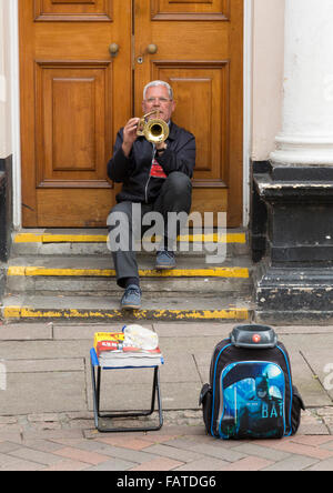 a street performer playing a trumpet in an urban setting with a ...
