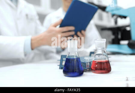 close up of scientists with flasks and tablet pc Stock Photo - Alamy