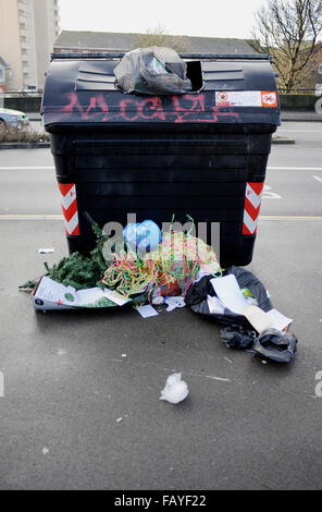 Christmas tree with ornaments thrown away beside a bench, garbage and ...