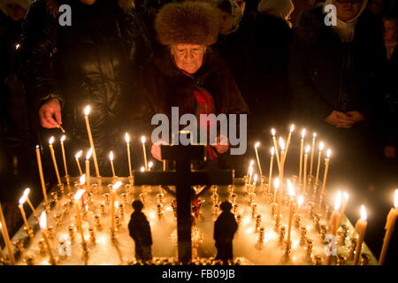 A woman lights a candle during a service celebrating the Annunciation ...