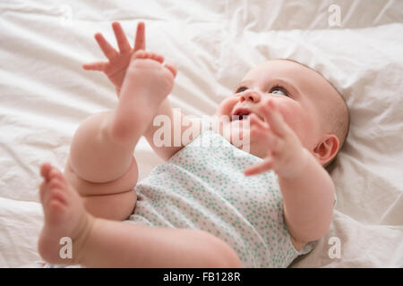 Excited baby girl looking away on bed in morning,stock image Stock ...