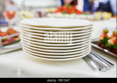Stack of clean plates with knifes ready to be used on dinner Stock ...