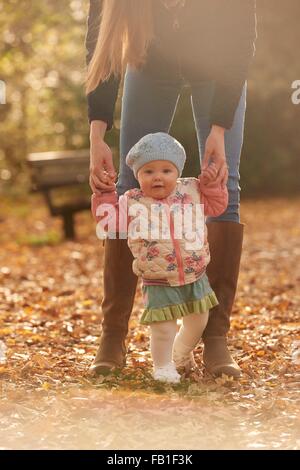 cute baby girl in autumn park eating lollipop Stock Photo - Alamy