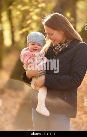 cute baby girl in autumn park eating lollipop Stock Photo - Alamy