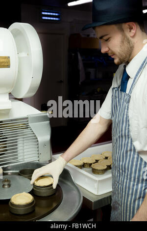 Making pork pies in a factory with an automated machine Stock Photo - Alamy