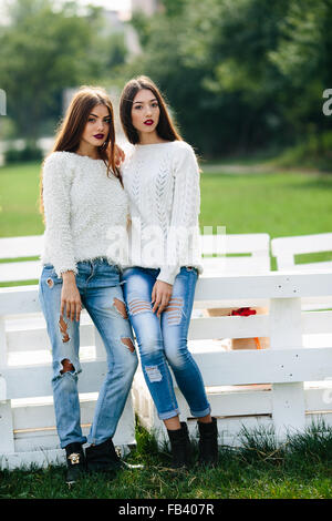 Two girls lean bench Stock Photo - Alamy