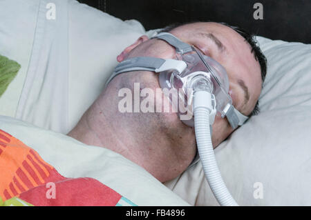 Overweight man wearing CPAP Continuous Positive Airway Pressure device ...