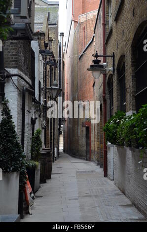 Narrow alley between tall buildings on a cloudy day Stock Photo - Alamy