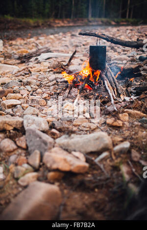 Container hanging over campfire in forest Stock Photo - Alamy