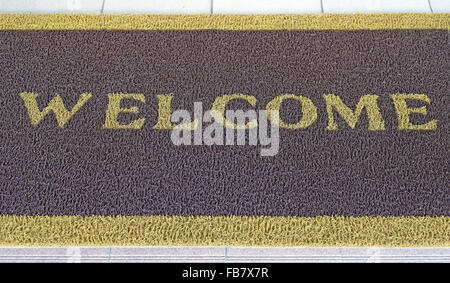Brown doormat with welcome text on it with floor background. Welcome ...