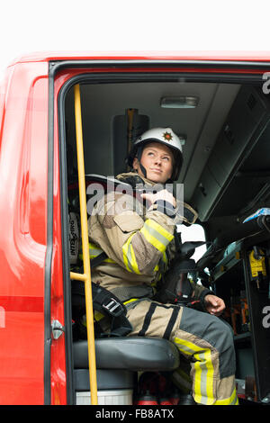 Fireman sitting in fire engine looking out window Stock Photo - Alamy