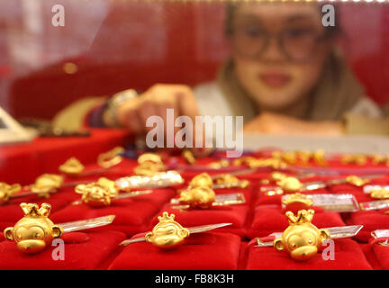 A staff member arranges gold jewelry at a store in Hangzhou, east China ...