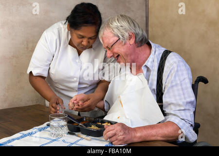 Grumpy old grandpa in nursing home receiving medication by a nurse ...