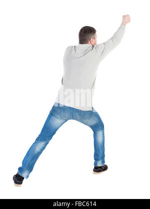 Young man pulling something behind him. Concept of manipulation and ...