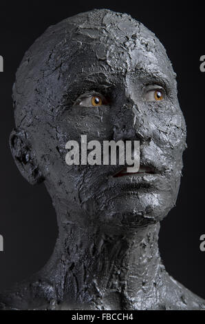 Statuesque woman in clay. Woman covered in clay. Spa treatment or ...