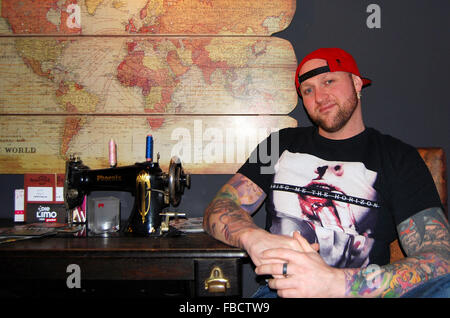 Randy Engelhard sitting in front of a map of the world in his tattoo ...