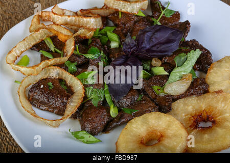 Grilled liver with onion rings and herbs Stock Photo - Alamy
