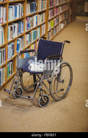 Wheelchair with books in bookshelves Stock Photo - Alamy