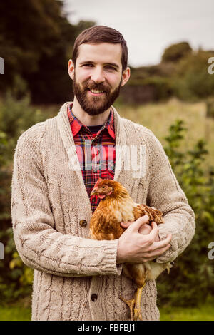 Smiling man holding chicken Stock Photo - Alamy