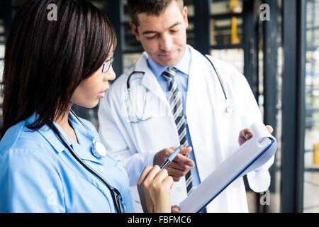 Concentrated female doctor with stethoscope looking at digital tablet ...