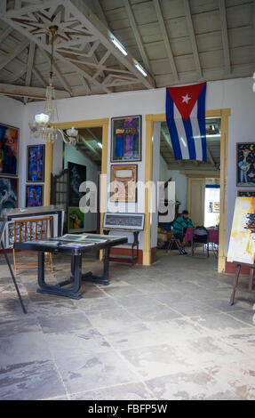 Painting in gallery with wrought iron grillwork casting shadow ...