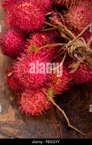 fresh tropical rambutan fruits over rustic wood table Stock Photo - Alamy