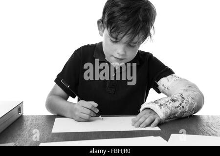 young boy drawing a picture , whilst he has a broken left arm Stock ...