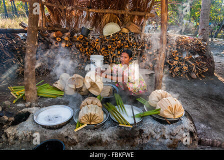A woman boiling the sap of the Palmyra palm (Arenga pinnata) to produce ...