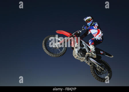Motocross biker jumping over dirt track Stock Photo - Alamy