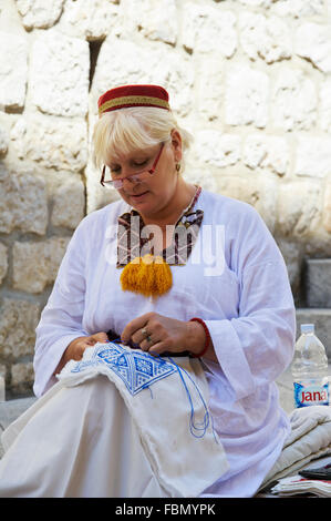 A woman doing some needlework and selling her finish work in Old Town ...