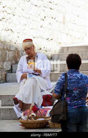 A woman doing some needlework and selling her finish work in Old Town ...