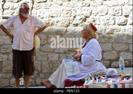 A woman doing some needlework and selling her finish work in Old Town ...