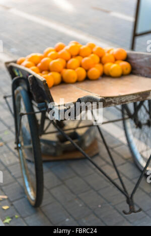 selective focus of pile of oranges in metal basket on blurred ...