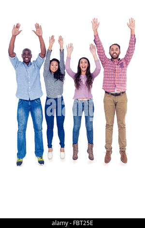 Happy friends jumping with arms raised at beach during sunny day Stock ...