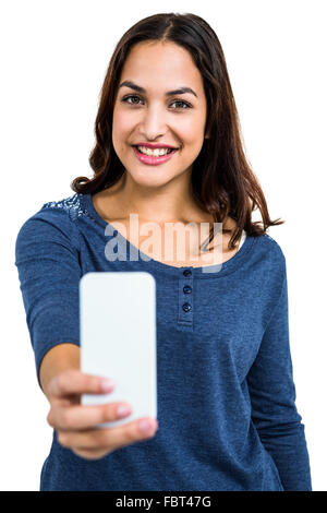 Beautiful young woman holding mobile phone against her mouth and ...