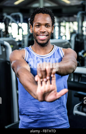 Smiling muscular man stretching arms Stock Photo - Alamy