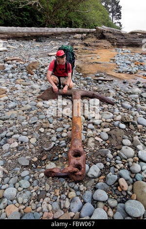 Old rusty anchor on rock by blue sea Stock Photo - Alamy