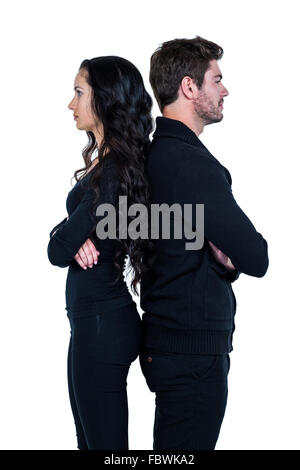 Frowning angry young couple standing with hands folded and thinking ...