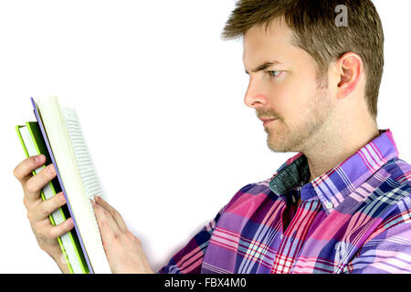 Thoughtful young man reading book on yellow background Stock Photo - Alamy