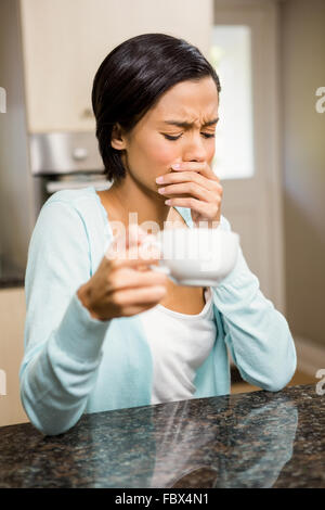 Young woman with sensitive teeth and cup of hot coffee on white ...