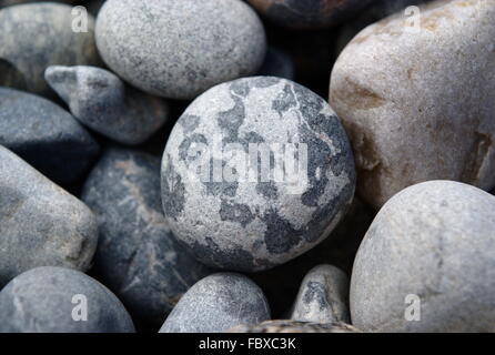 A photograph of smooth round granite rocks on a beach Stock Photo - Alamy
