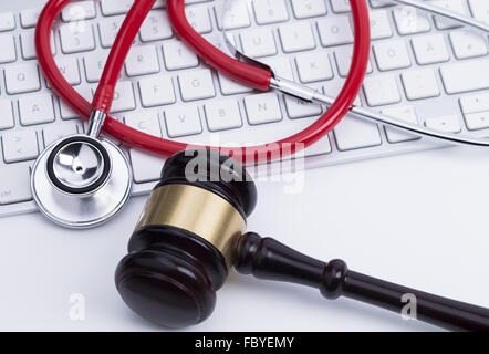 Judge gavel, PC keyboard, stethoscope, clipboard and first aid kit on ...