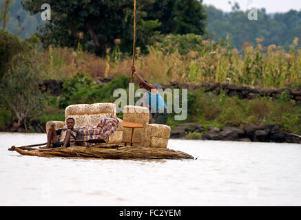 Ethiopia Lake Tana Papyrus raft near papyrus field at lake with village ...