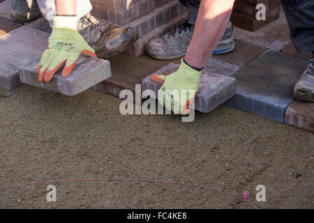 Construction workers laying block paving for container stacking areas ...