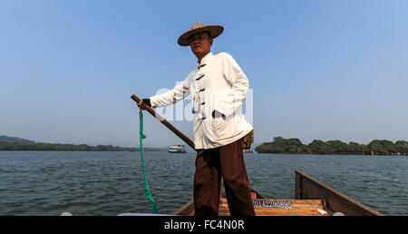 Boatman rows boat during tour on Hangzhou's West Lake. Tour boats ...